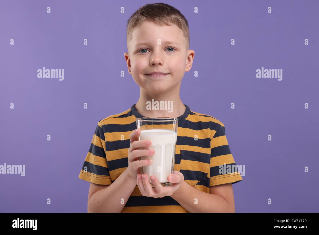 Cute boy with glass of fresh milk on violet background Stock Photo - Alamy
