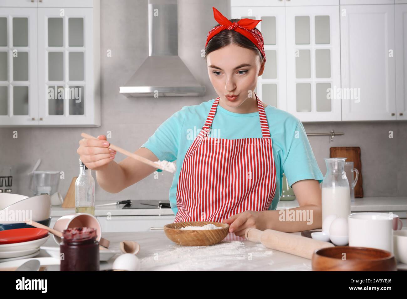 Beautiful woman cooking in kitchen. Dirty dishware, food leftovers and ...