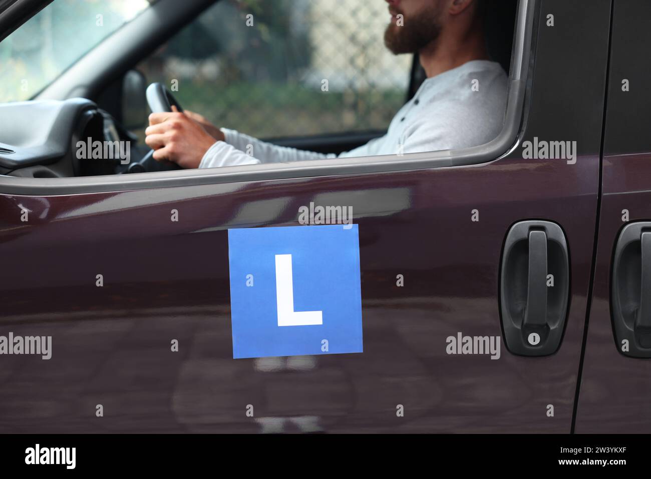 Learner driver driving car with L-plate, view from outside. Driving ...
