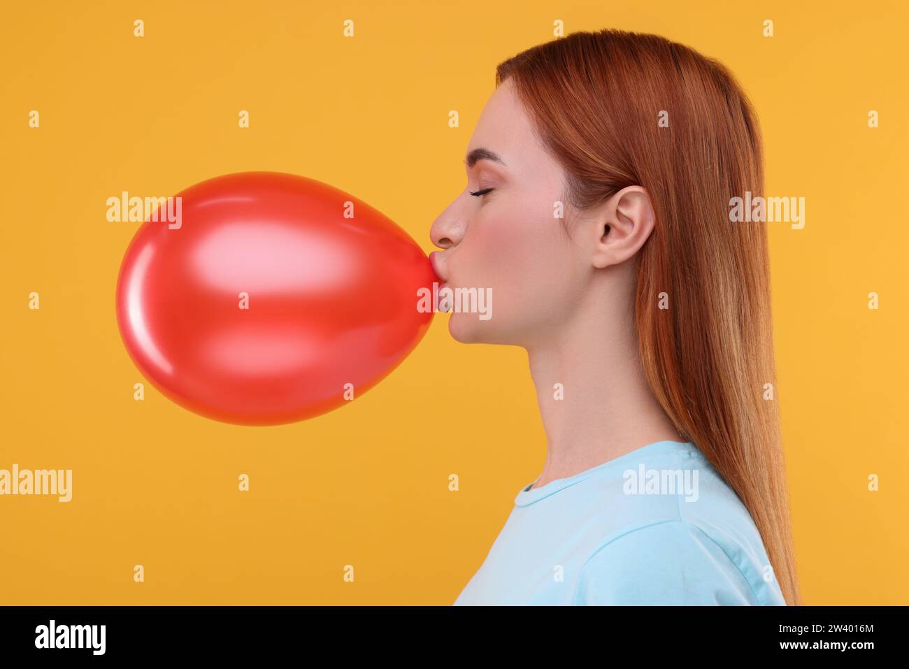 Young woman inflating red balloon hi-res stock photography and images ...