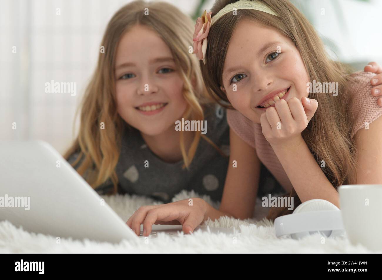 Two cute little girls with a laptop Stock Photo - Alamy