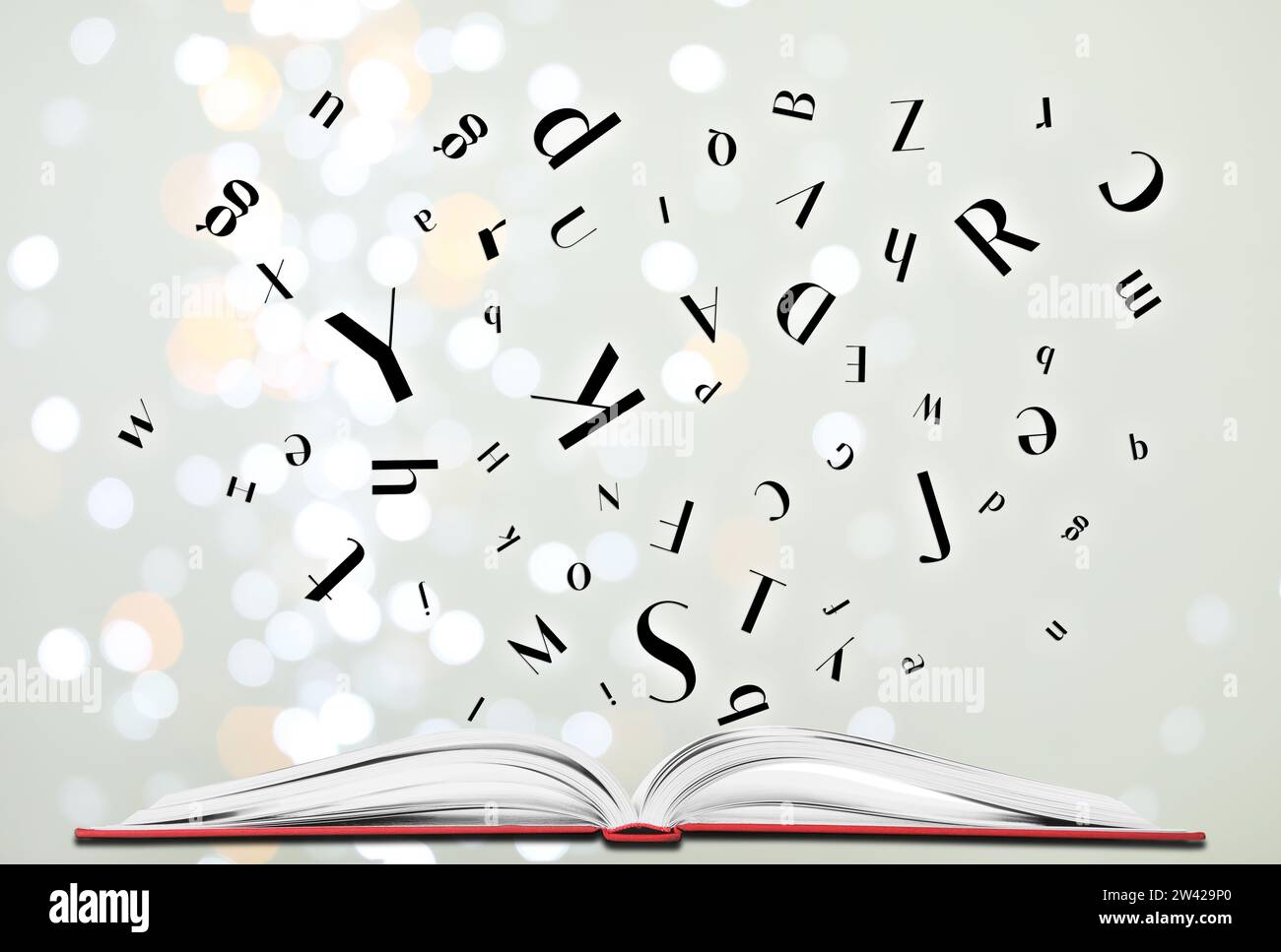 Letters flying out from open book on light grey background, bokeh effect Stock Photo - Alamy