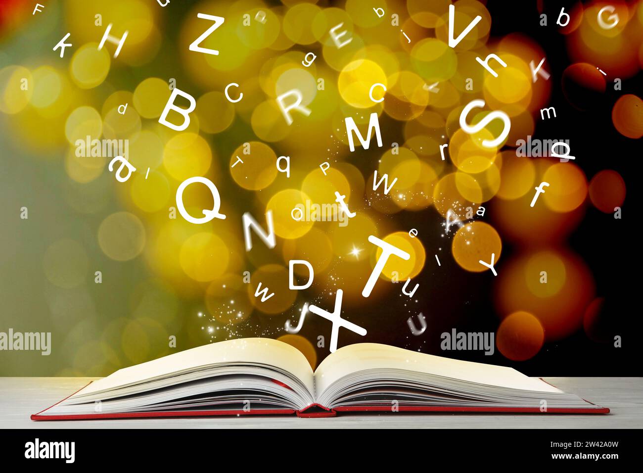 Letters flying out from open book on table, bokeh effect Stock Photo ...