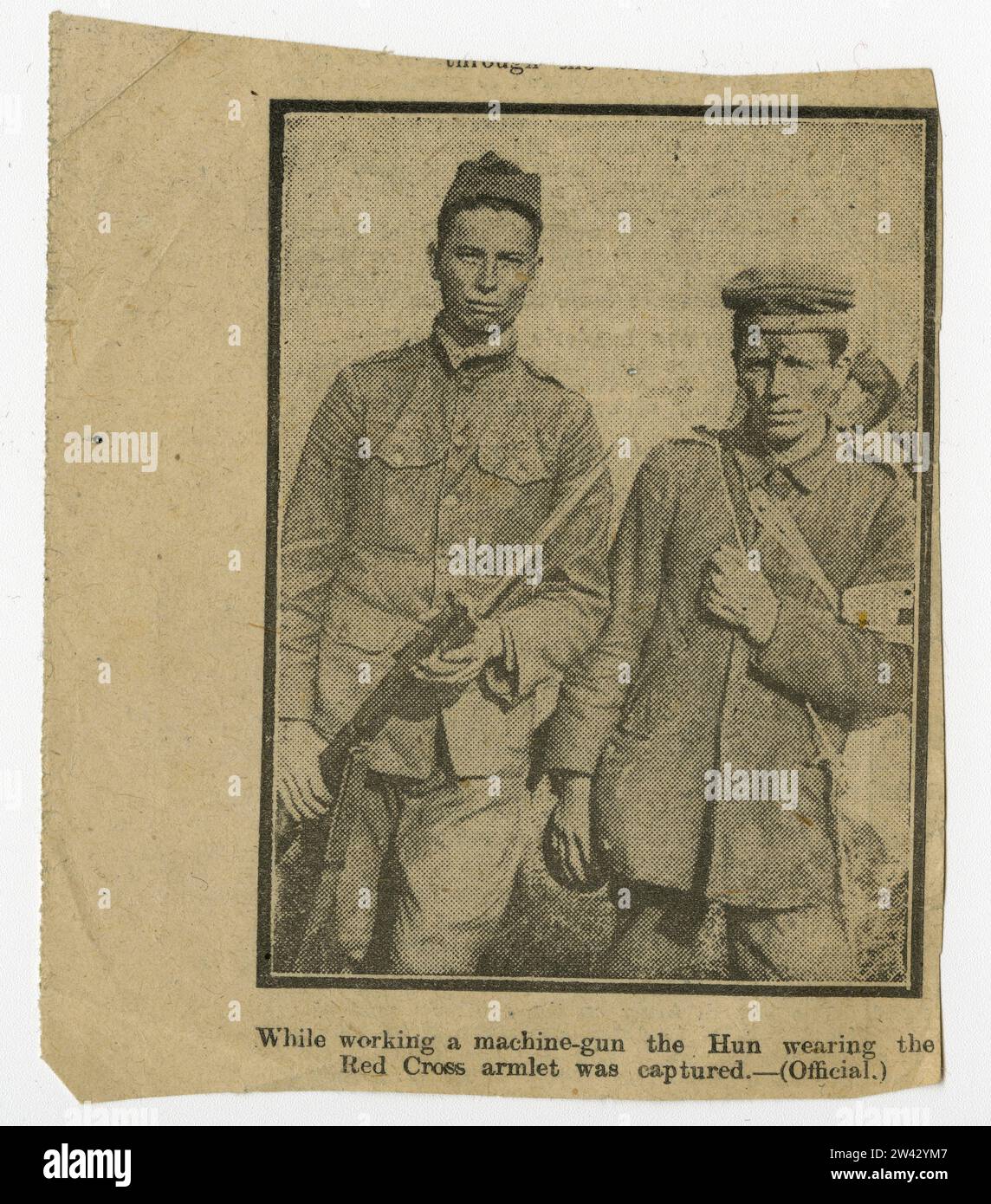 Official photograph with caption 'While working a machine-gun the Hun ...