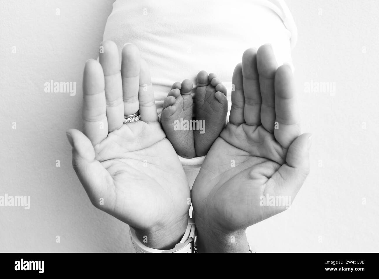 The palms of the parents, father and mother hold the legs, feet of ...