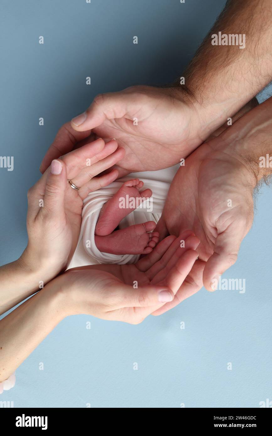 The palms of the parents, father and mother hold the legs, feet of ...
