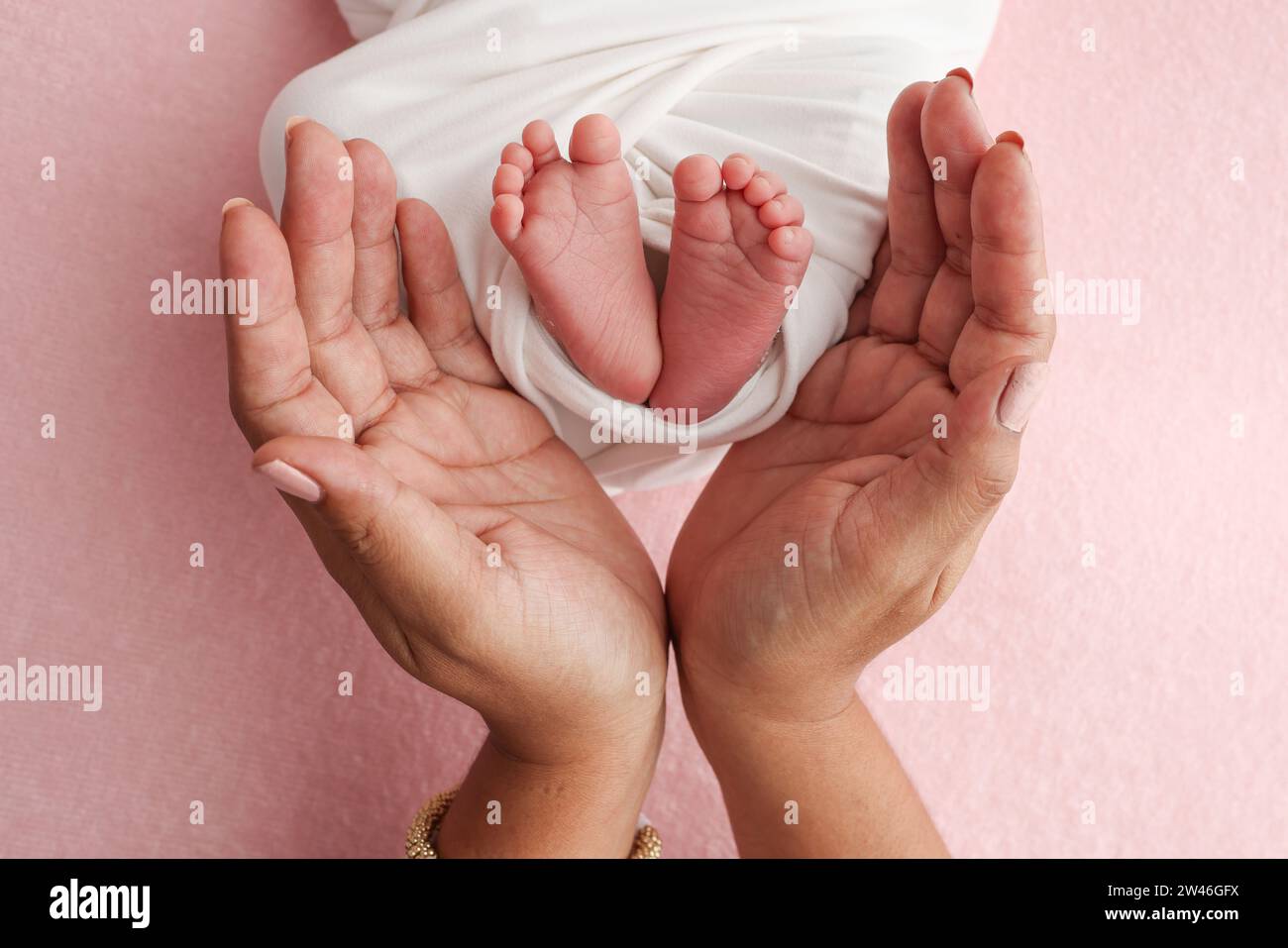 The palms of the parents, father and mother hold the legs, feet of ...
