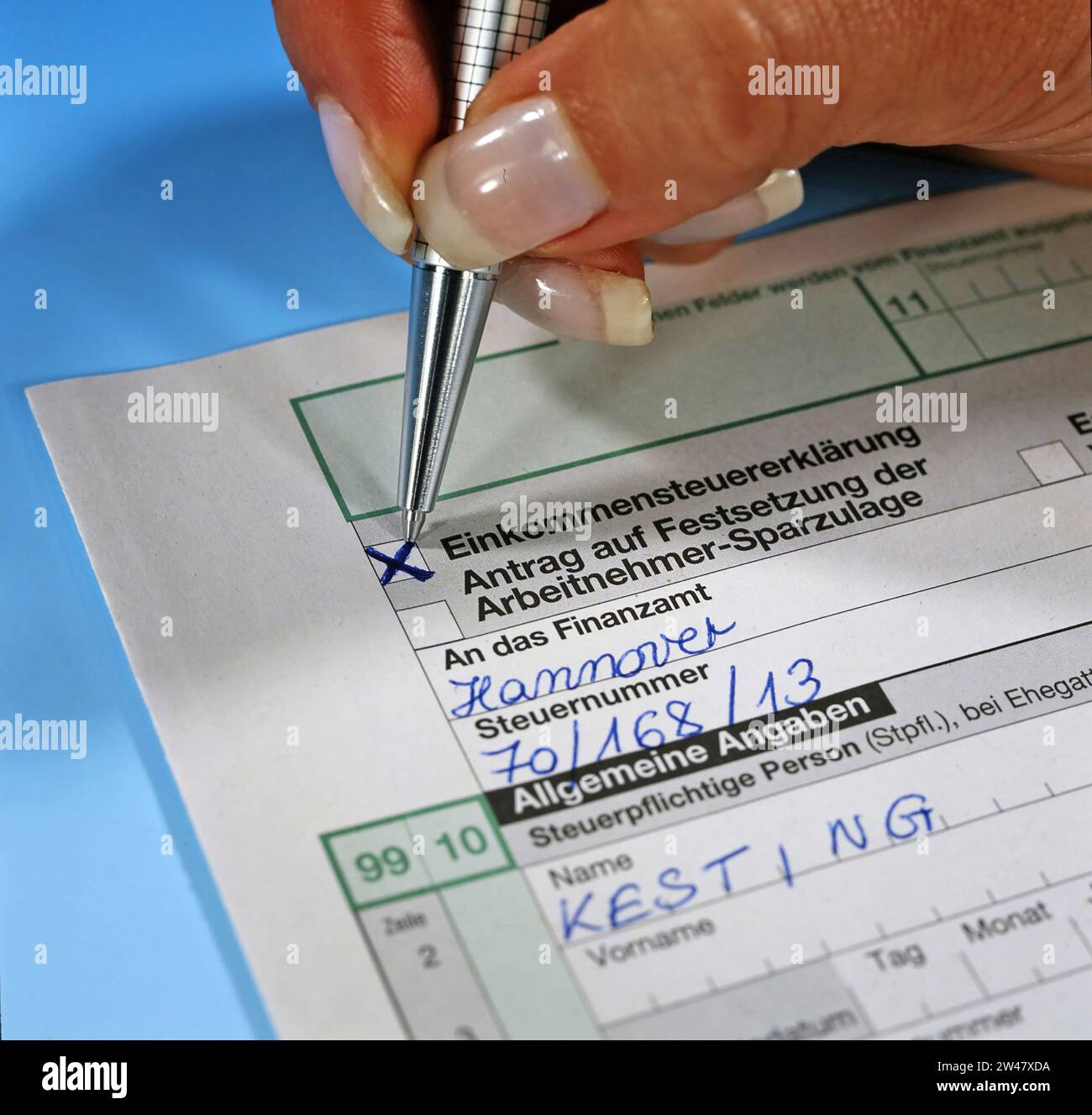 Eine Frauenhand Hand mit Kugelschreiber füllt das Formular zur ...