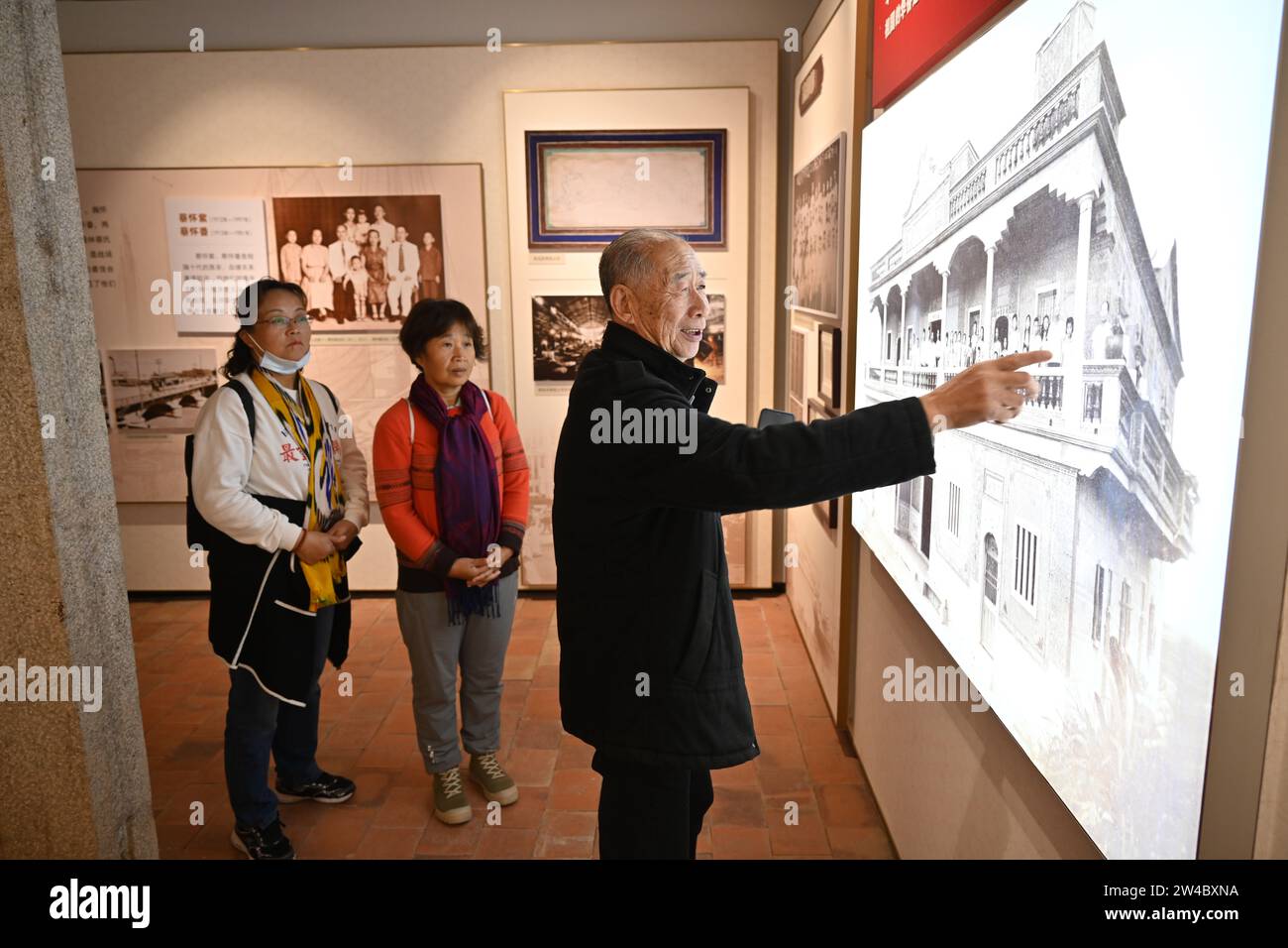 JINJIANG, Dec. 21, 2023 (Xinhua) -- Local villager Cai Wenshi (R) talks ...