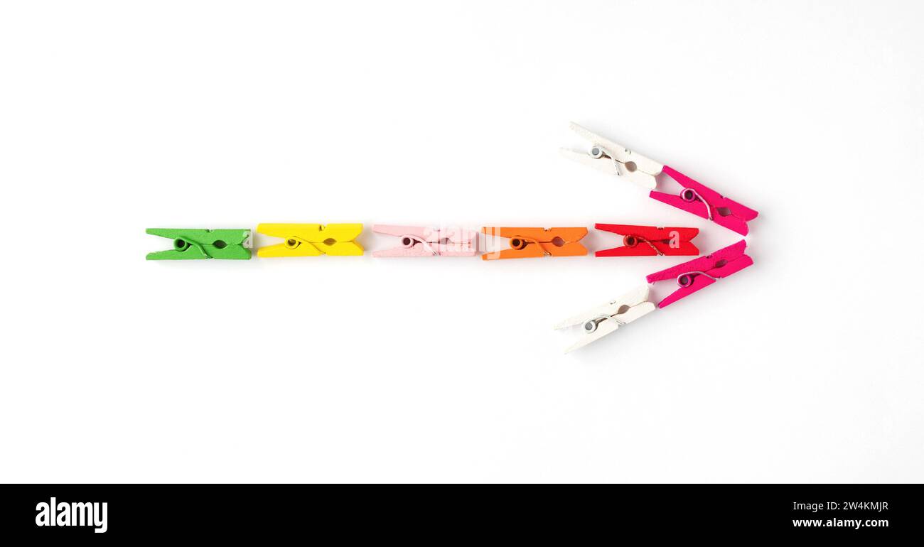 Colored wooden clothespins in shape of arrow on white background. Top ...
