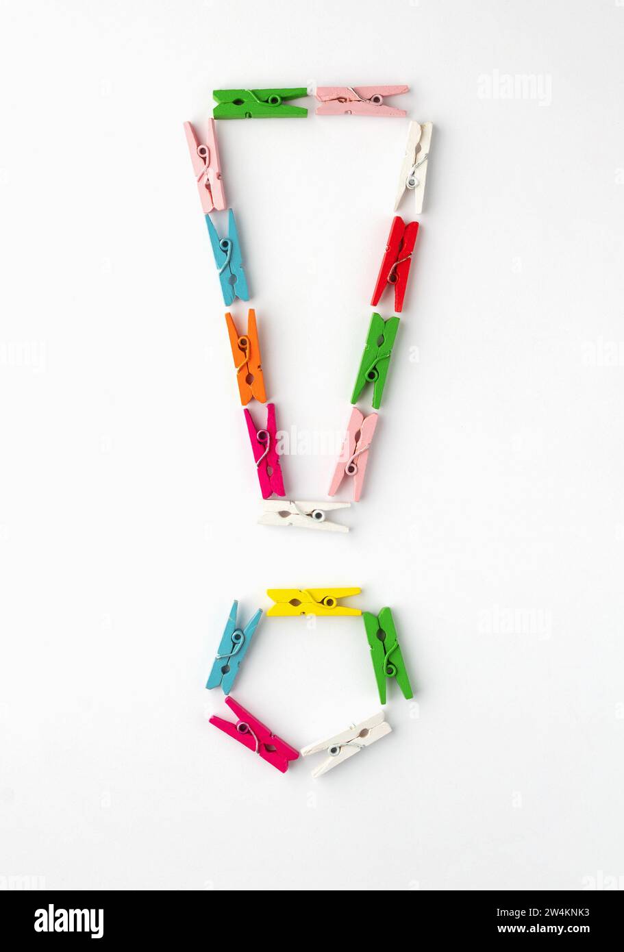 Exclamation mark laid out of colored wooden clothespins on white ...