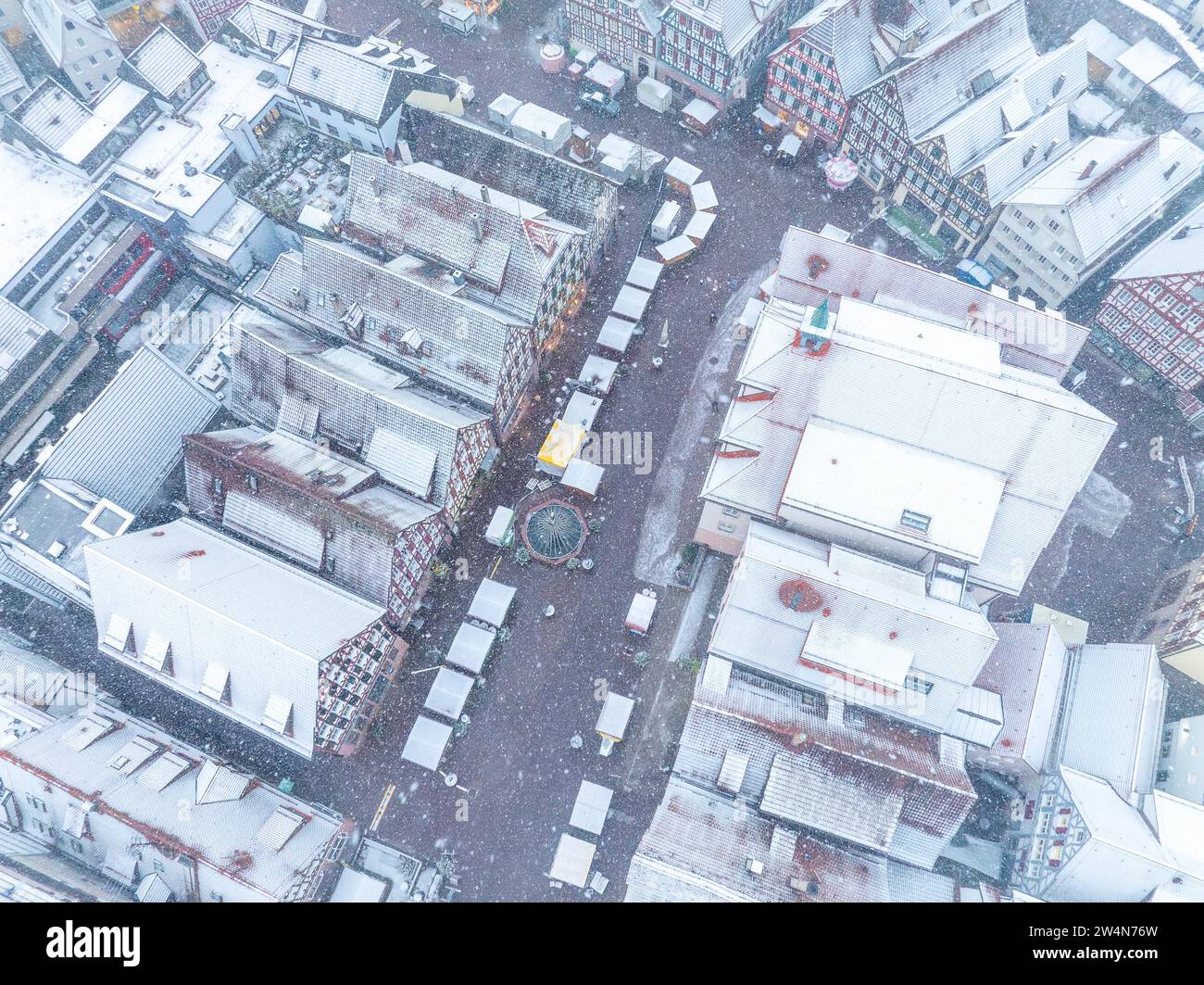 Bird's eye view of a town in winter, the roofs and streets are covered ...