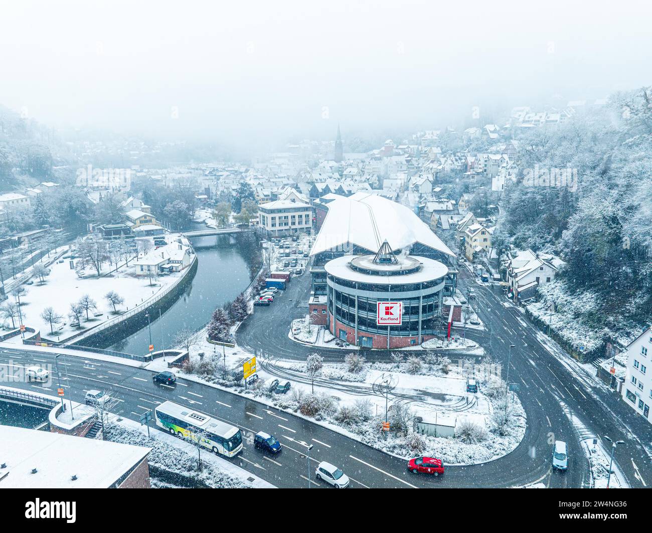Aerial view of a modern urban centre with snow on a river near a bridge ...