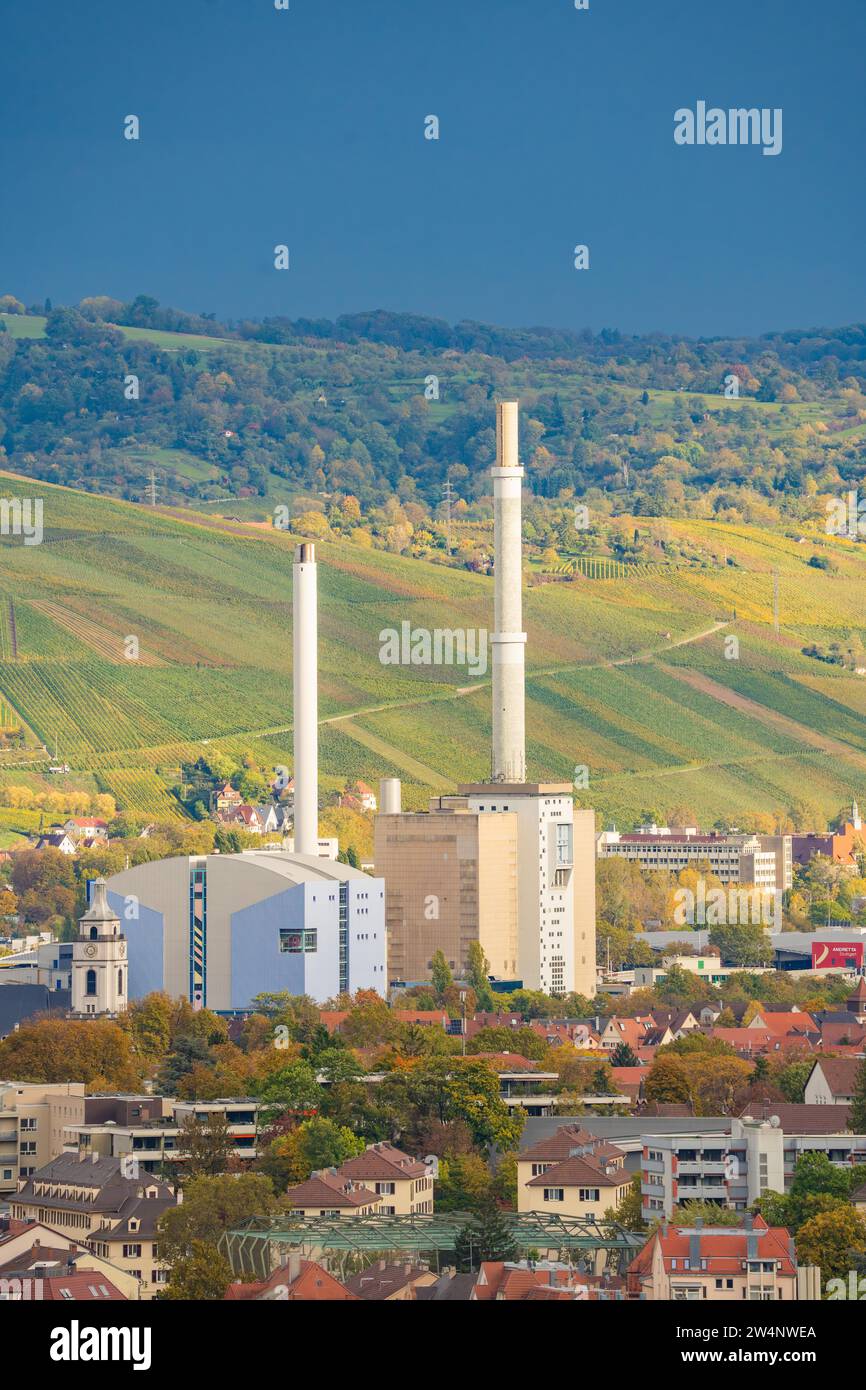 Industrial building with tall chimneys against an urban backdrop and ...