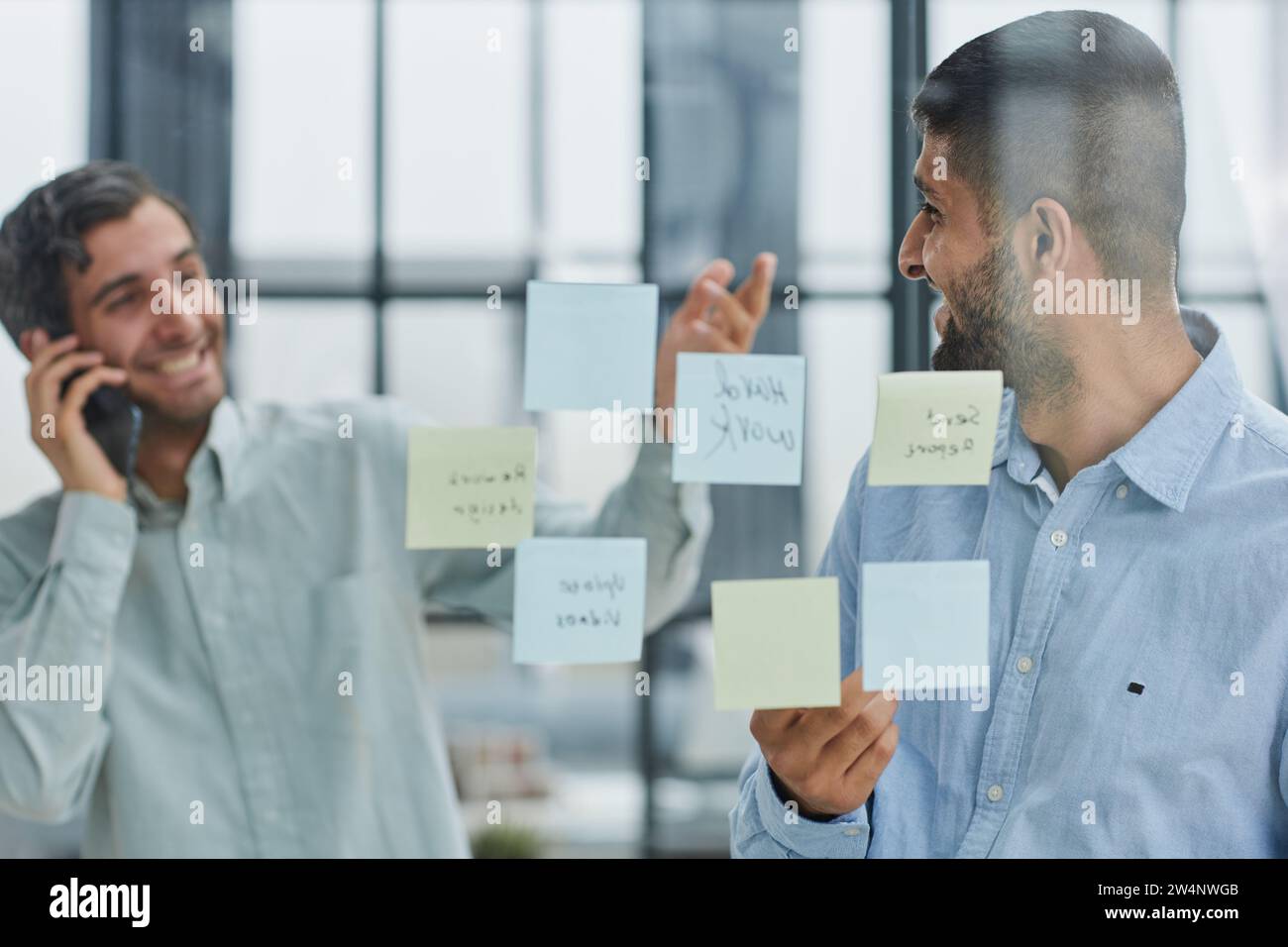two successful businessmen in the office discuss a plan on stickers ...