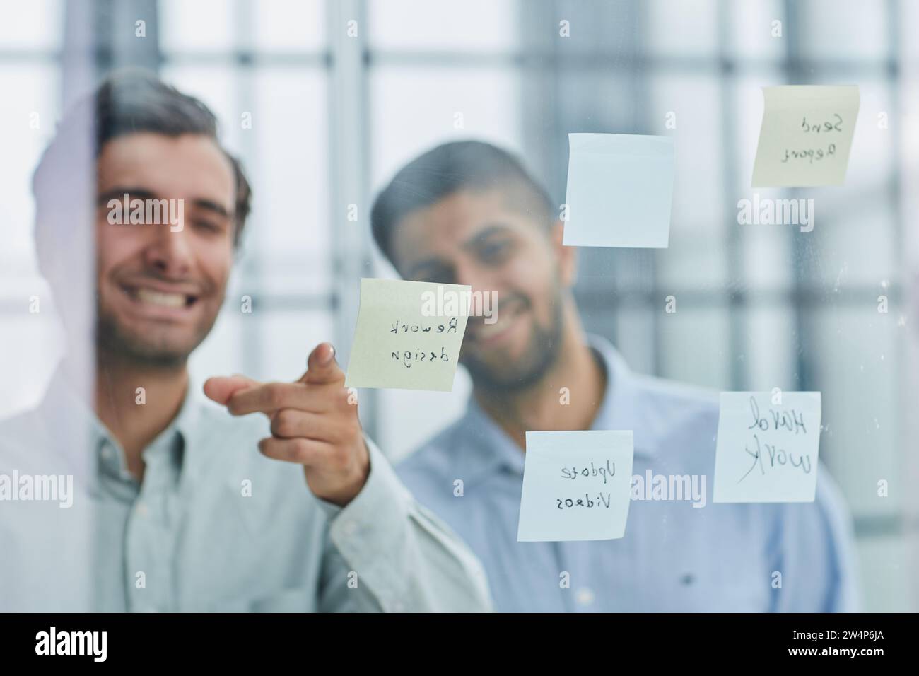 two successful businessmen in the office discuss a plan on stickers ...