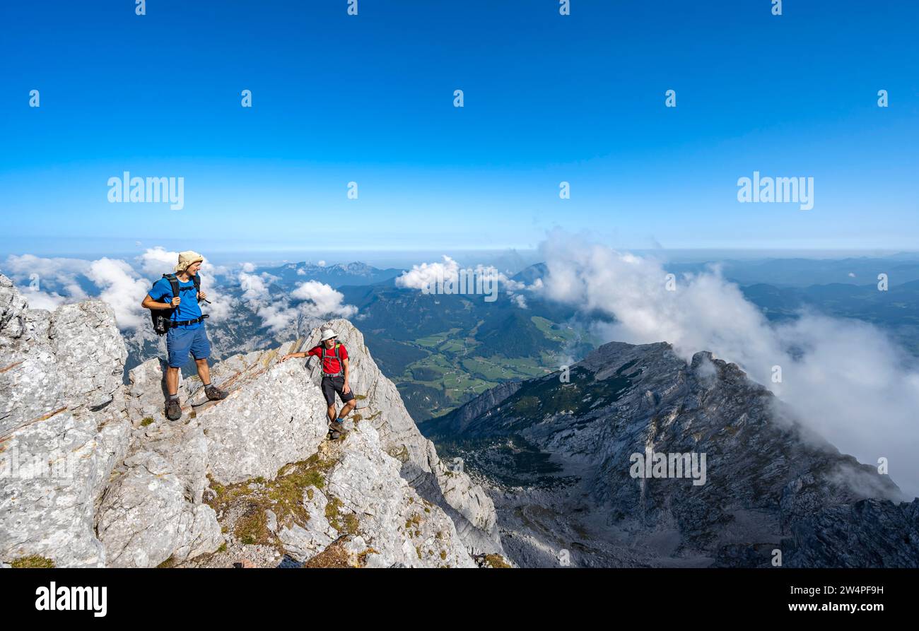 Mountaineer on a rocky narrow mountain path with mountain panorama ...