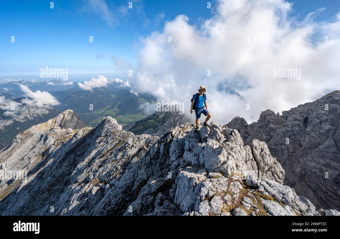 Mountaineer on a rocky narrow mountain path with mountain panorama ...