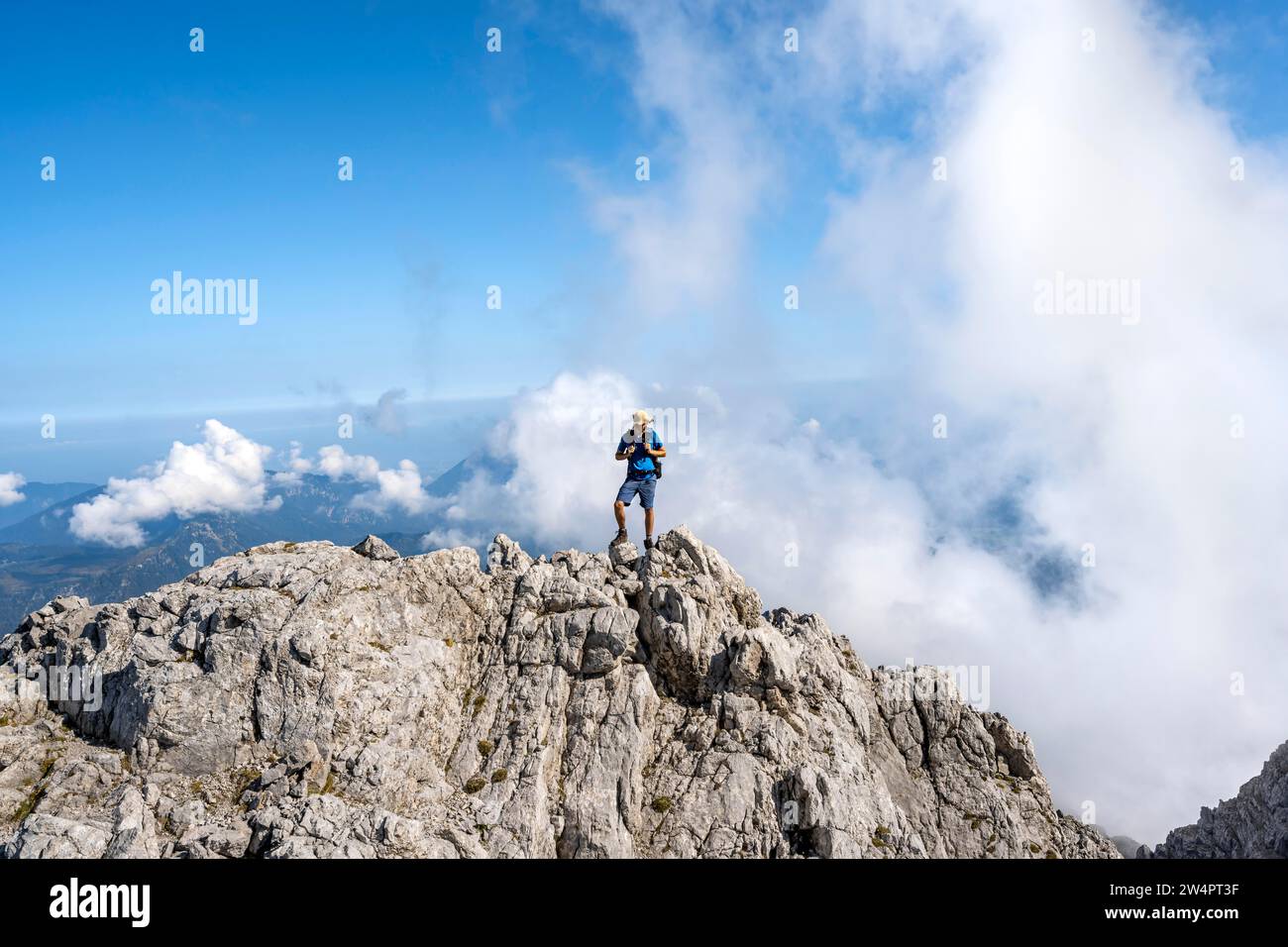 Mountaineer on a rocky narrow mountain path with mountain panorama ...