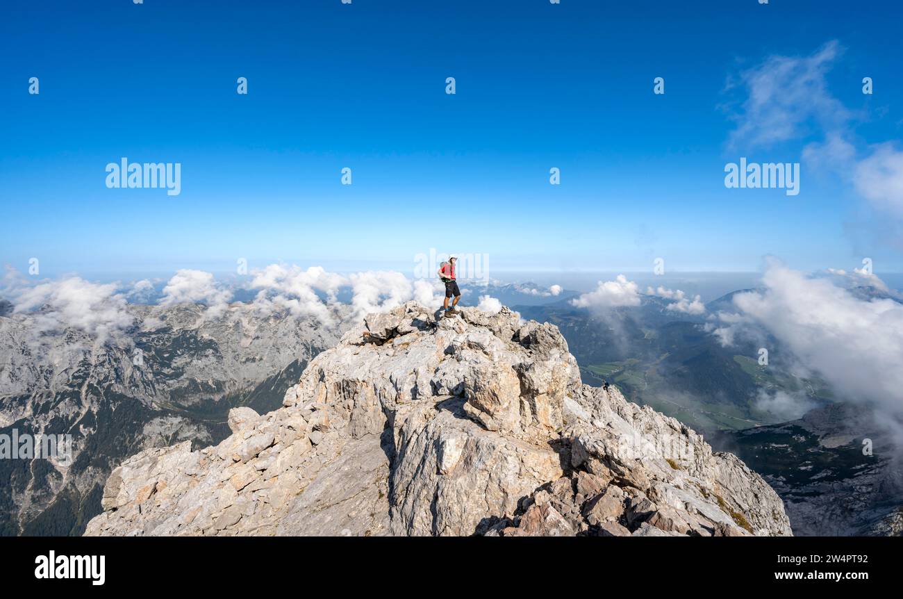 Mountaineer on a rocky narrow mountain path with mountain panorama ...