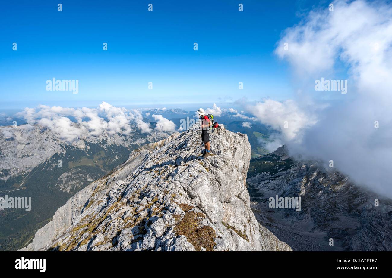Mountaineer on a rocky narrow mountain path with mountain panorama ...