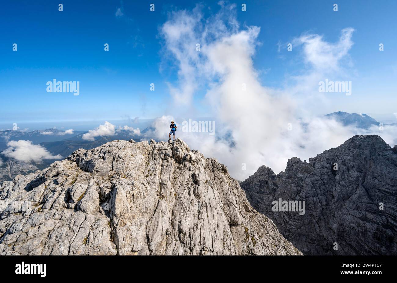 Mountaineer on a rocky narrow mountain path with mountain panorama ...