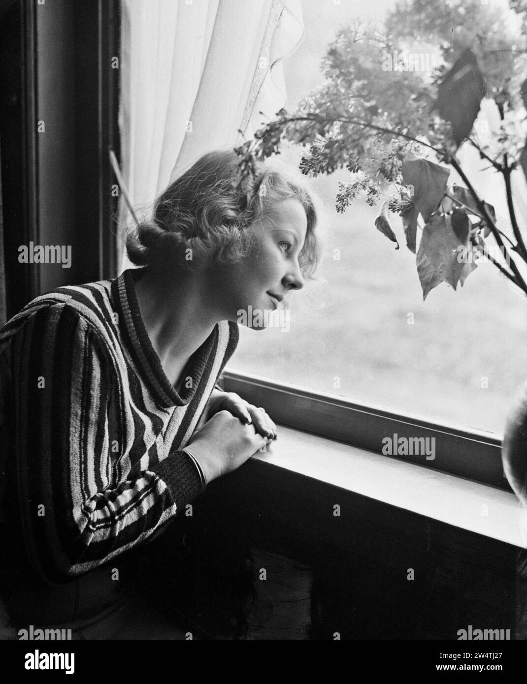 Model Eva Waldschmidt looks out the window ca. 1933 Stock Photo - Alamy