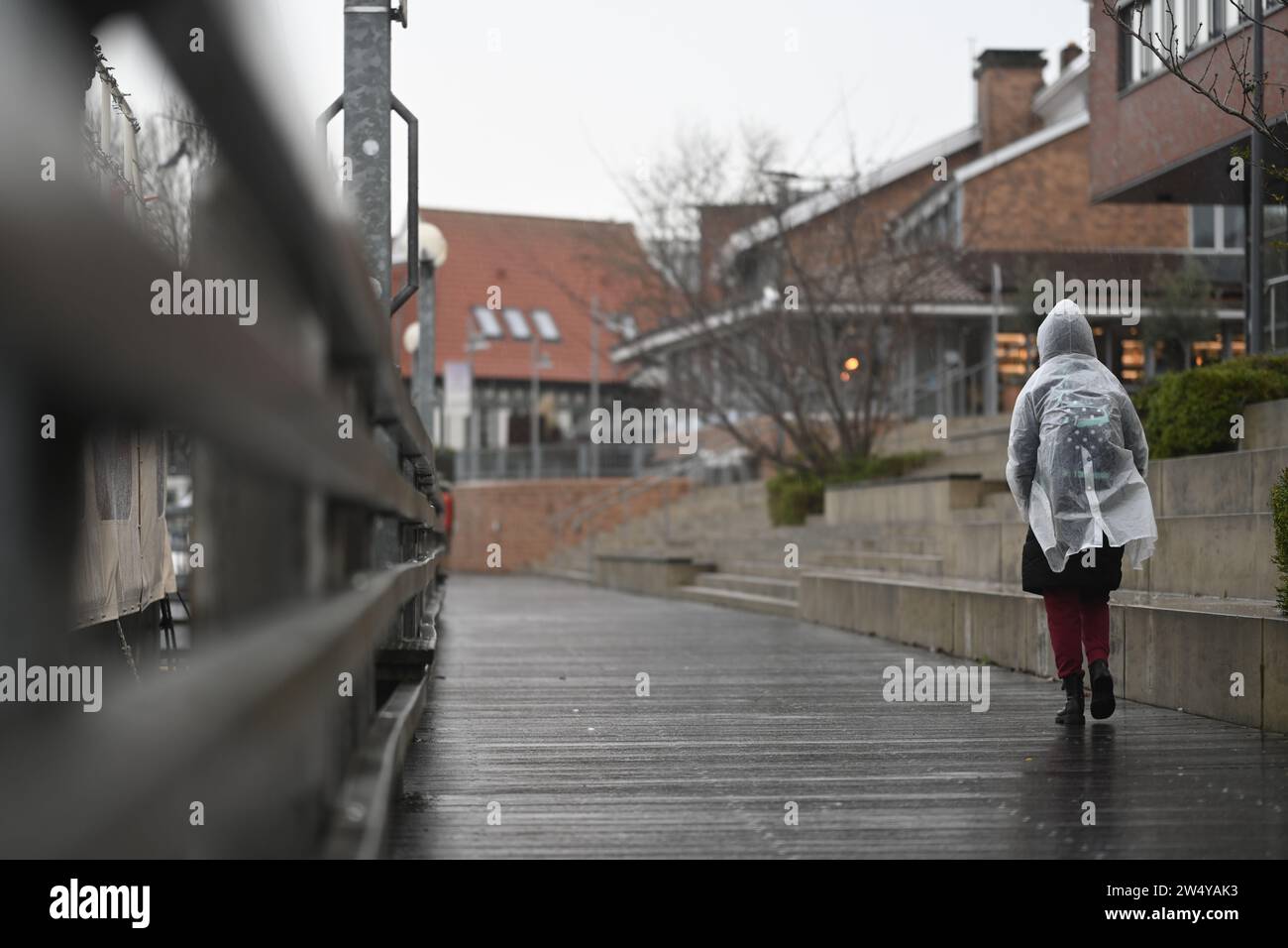 Leer, Germany. 21st Dec, 2023. A woman walks through the rain. The ...