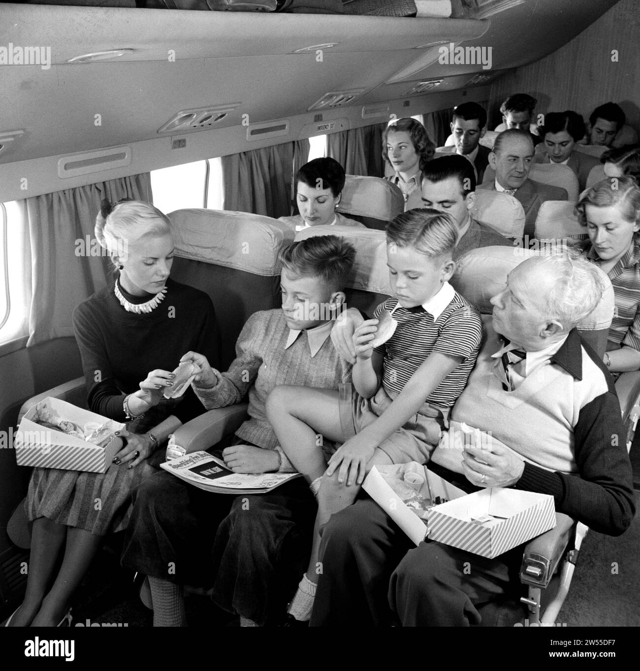 Passengers eat a sandwich on board a KLM passenger plane ca. 1950 Stock ...