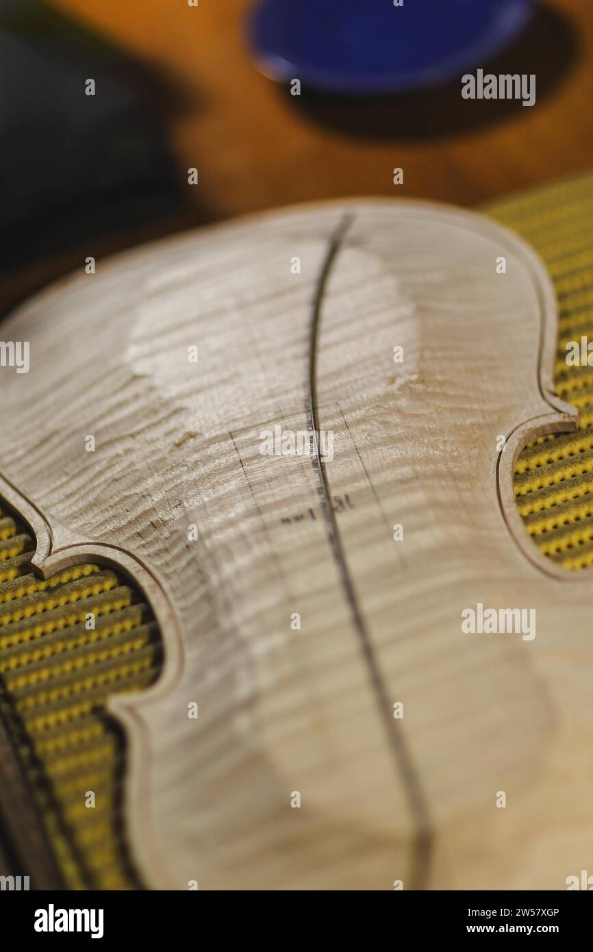 Front and back plates of new raw handmade classic violin on a workbench ...
