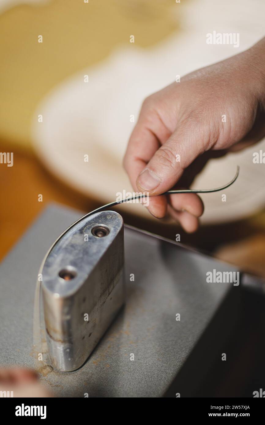 Unrecognizable luthier lute maker artisan both hands performing bend ...