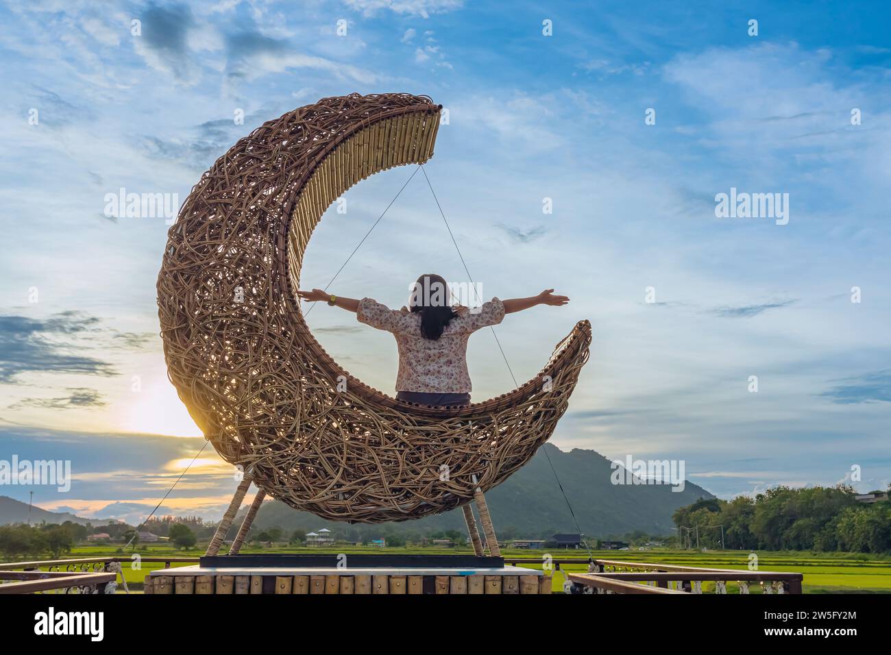 Woman sit on crescent moon chair made of rattan for relaxation on ...