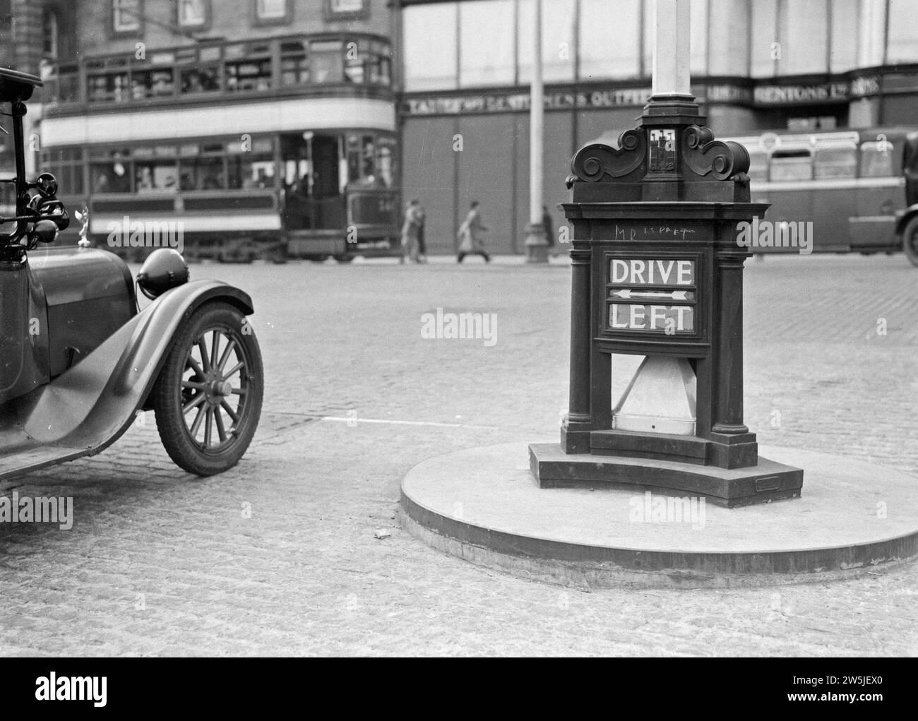 Car passes sign instructing to keep left ca. 1934 Stock Photo - Alamy