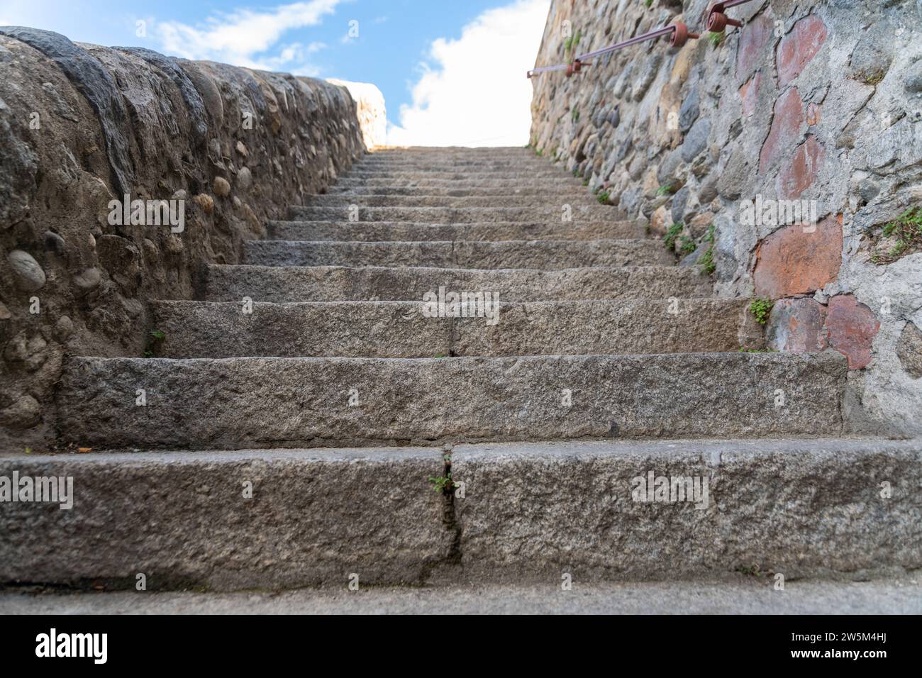 A stone staircase leading upwards, lined by a high stone wall on the ...