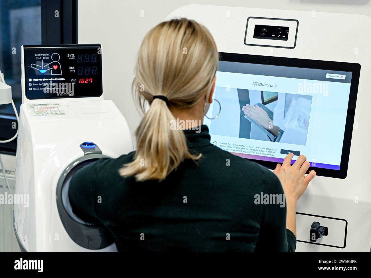 Berlin, Germany. 13th Dec, 2023. A woman at a self-measurement station ...