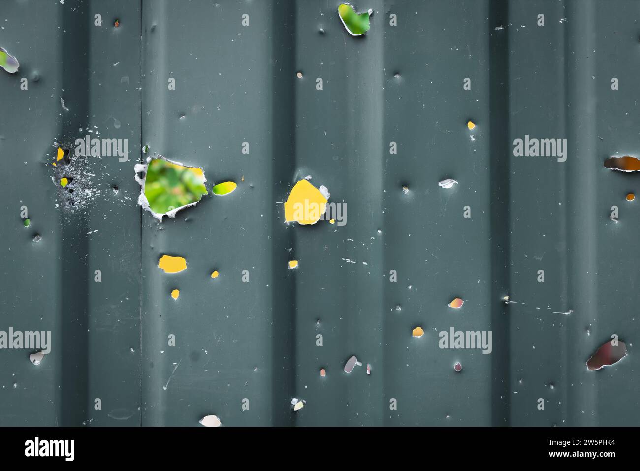 Fence with holes from shell fragments due to mortar shelling. Irpin ...