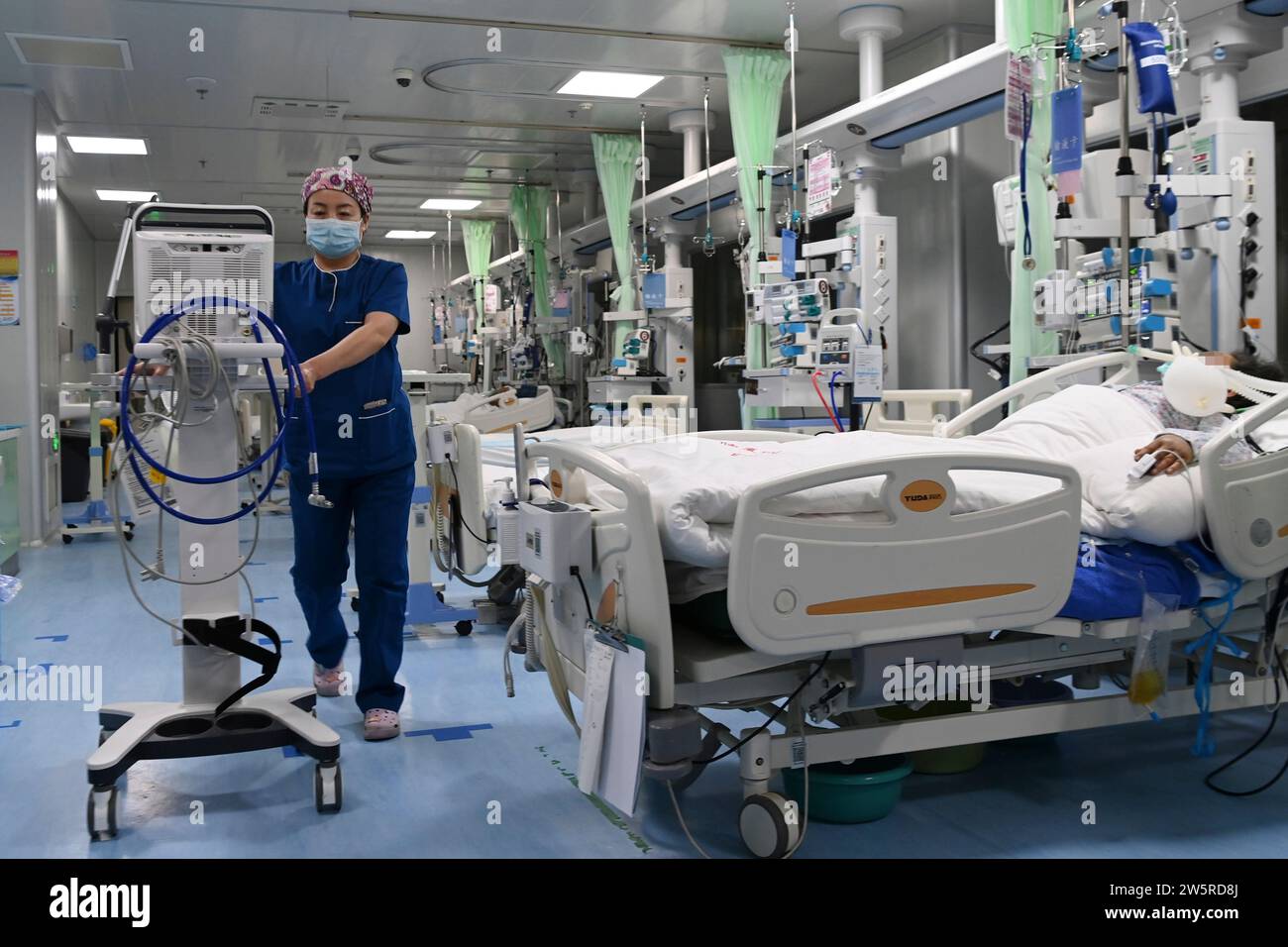 Linxia. 21st Dec, 2023. A medical worker transports medical equipment ...