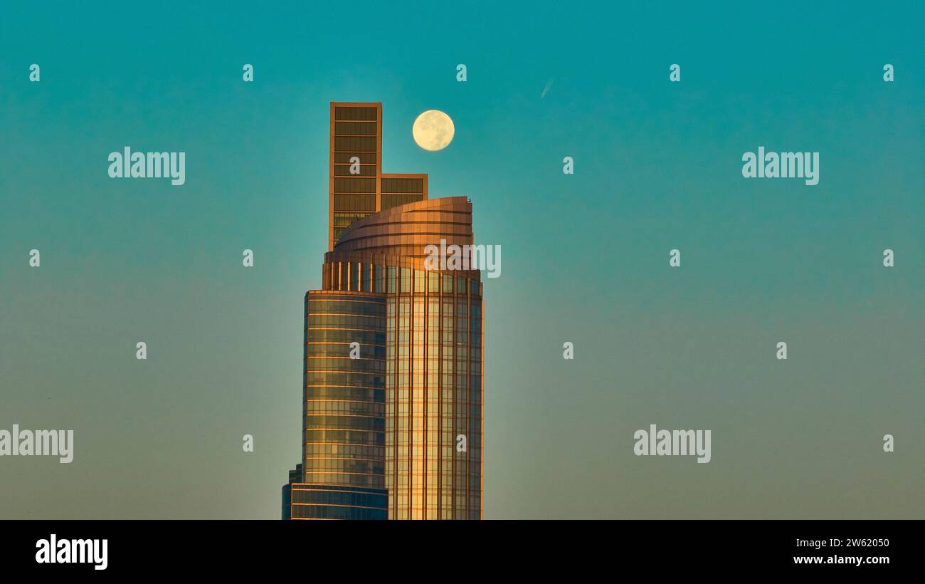 Mystic moon over two skyscraper buildings with teal blue sky in aerial ...