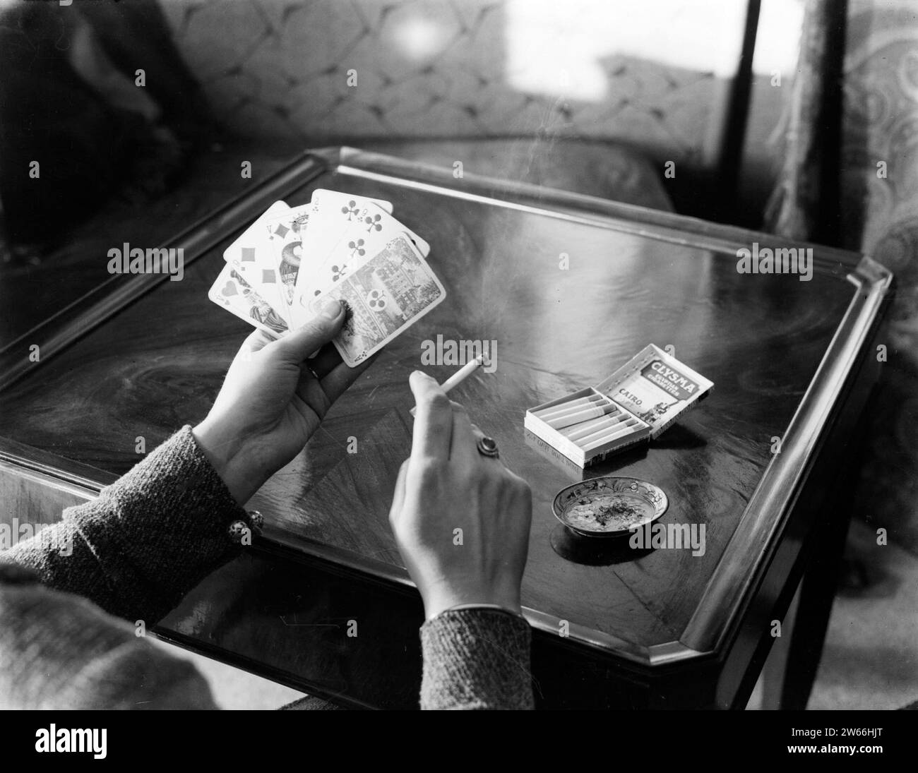 A woman playing cards and smoking a cigarette ca. undated Stock Photo ...
