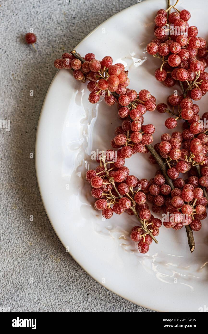 Top view of crop scattered organic buffaloberries on a white ceramic ...