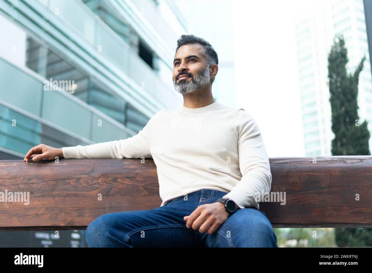 From below view of bearded indian businessman in casual outfit sitting ...