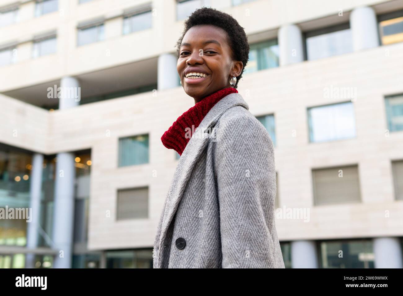 Low angle side view of smiling young African American female standing ...