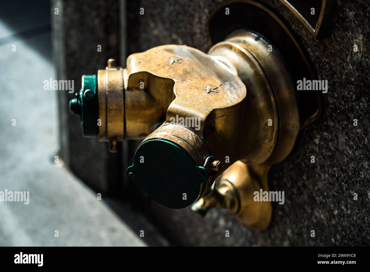High angle soft focus of shiny standpipe with green siamese connection ...