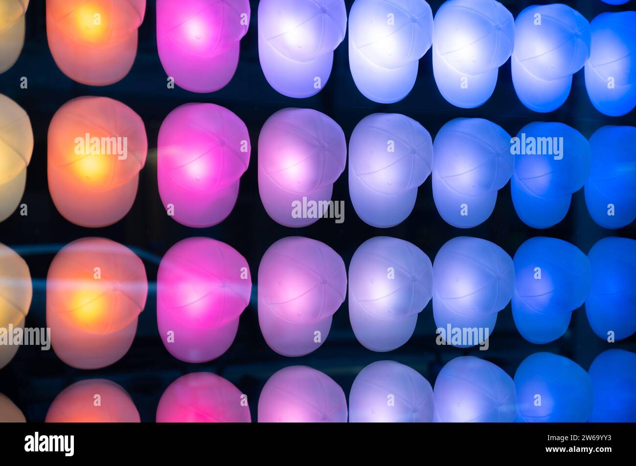 Abstract array of bright snapbacks with glowing multicolored LED light ...