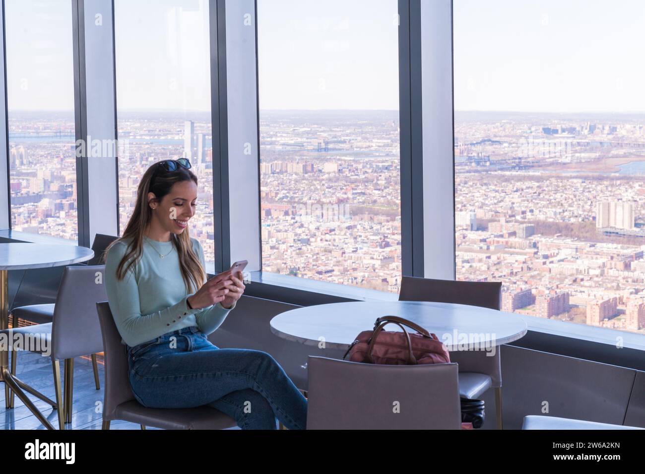 A woman comfortably seated at a high-rise cafe table, engrossed in her ...
