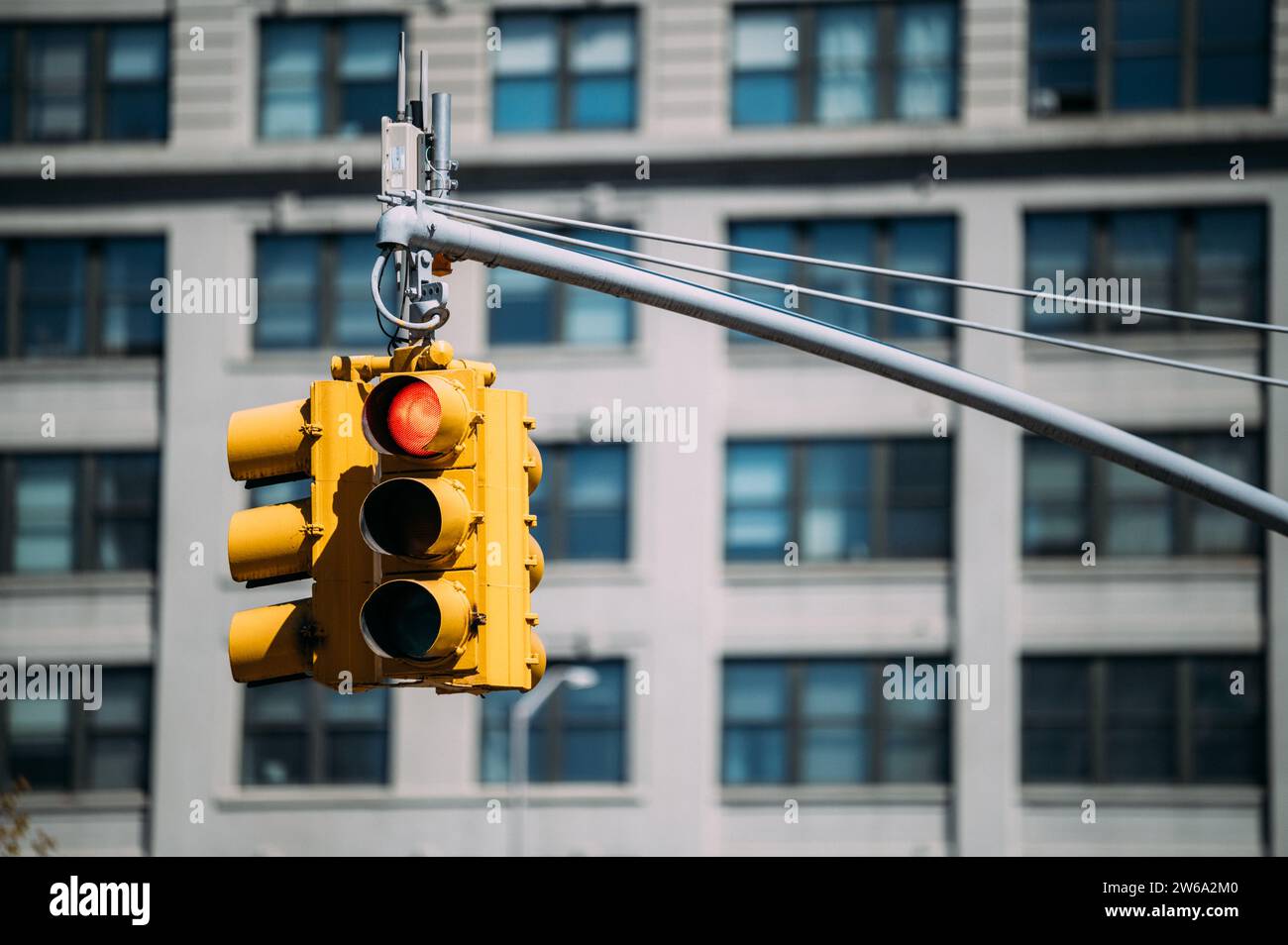 A vibrant yellow traffic light stands prominently against a backdrop of ...