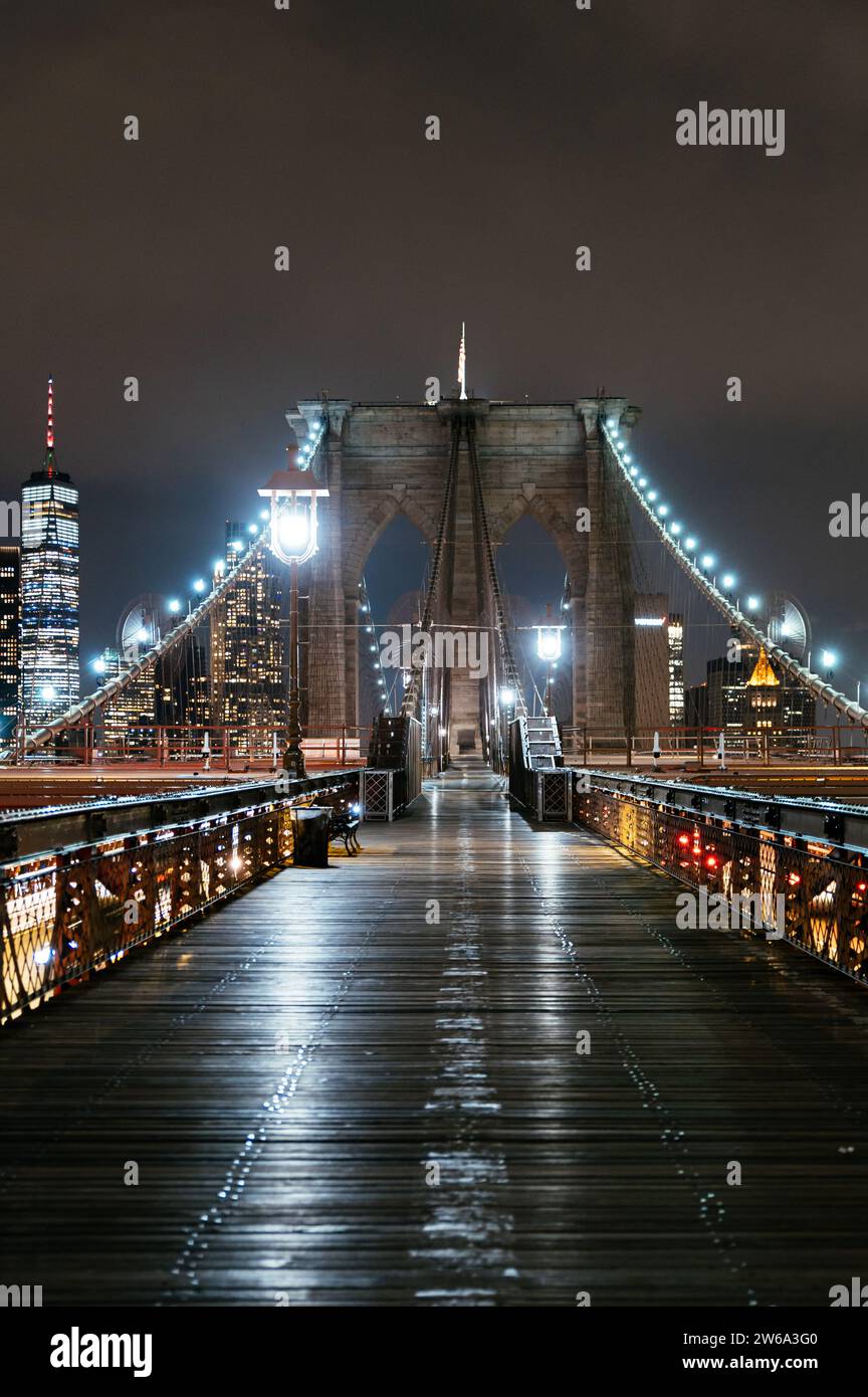 Night view of the Brooklyn Bridge walkway leading to the sparkling ...