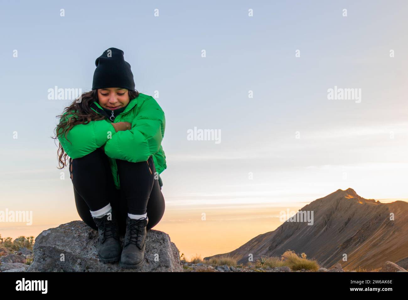 Full body of feeling cold female tourist with crossed hands on knees ...