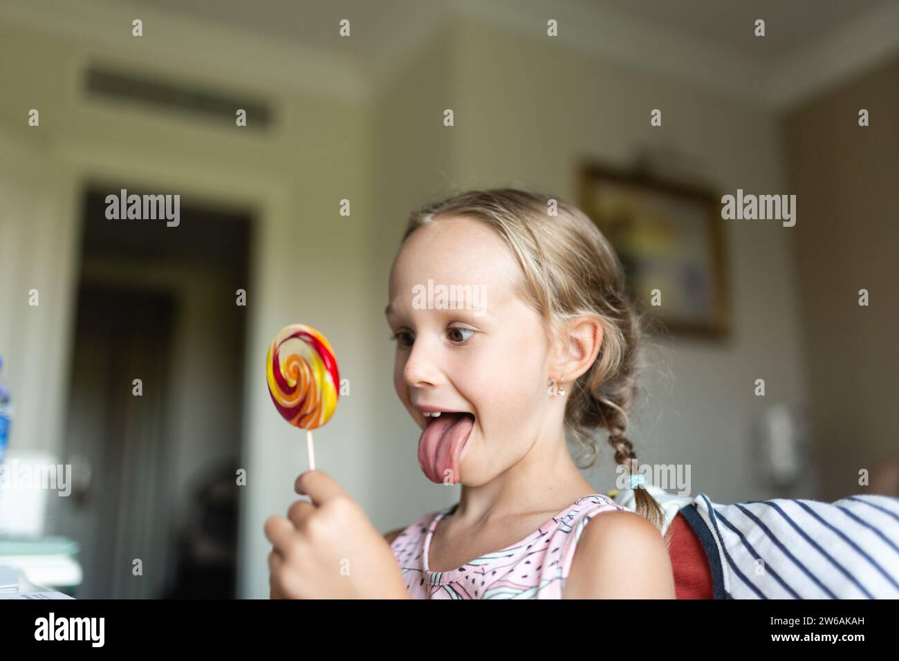 A cheerful young girl with braided hair delightedly looks at a large ...