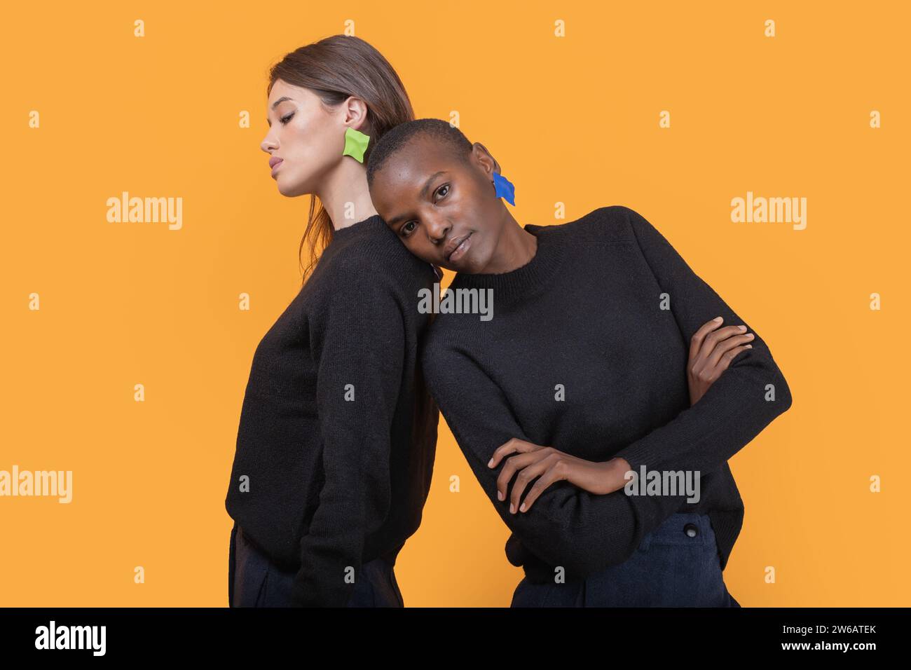 Side view of diverse young female friends leaning on each other looking ...